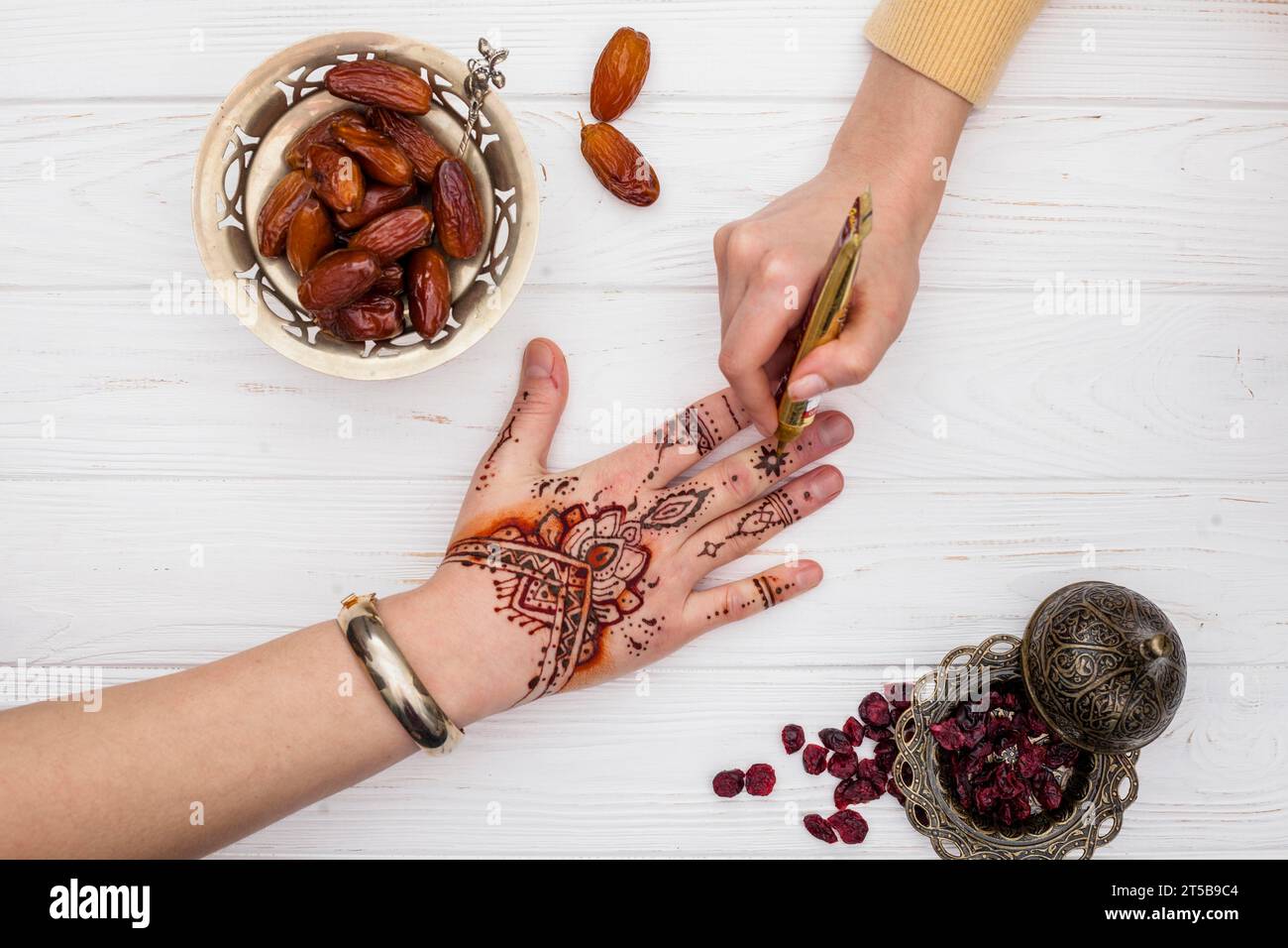 Artist making mehndi womans hand near dates fruit Stock Photo - Alamy