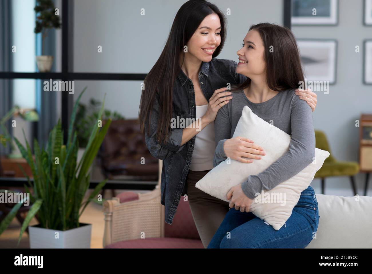 Beautiful young women smiling each other Stock Photo - Alamy