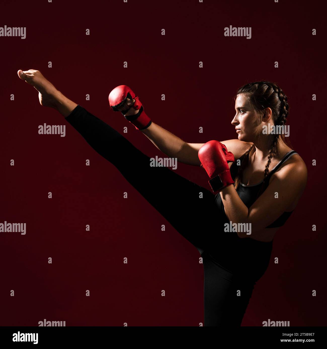Athletic woman fitness clothes giving kick Stock Photo - Alamy