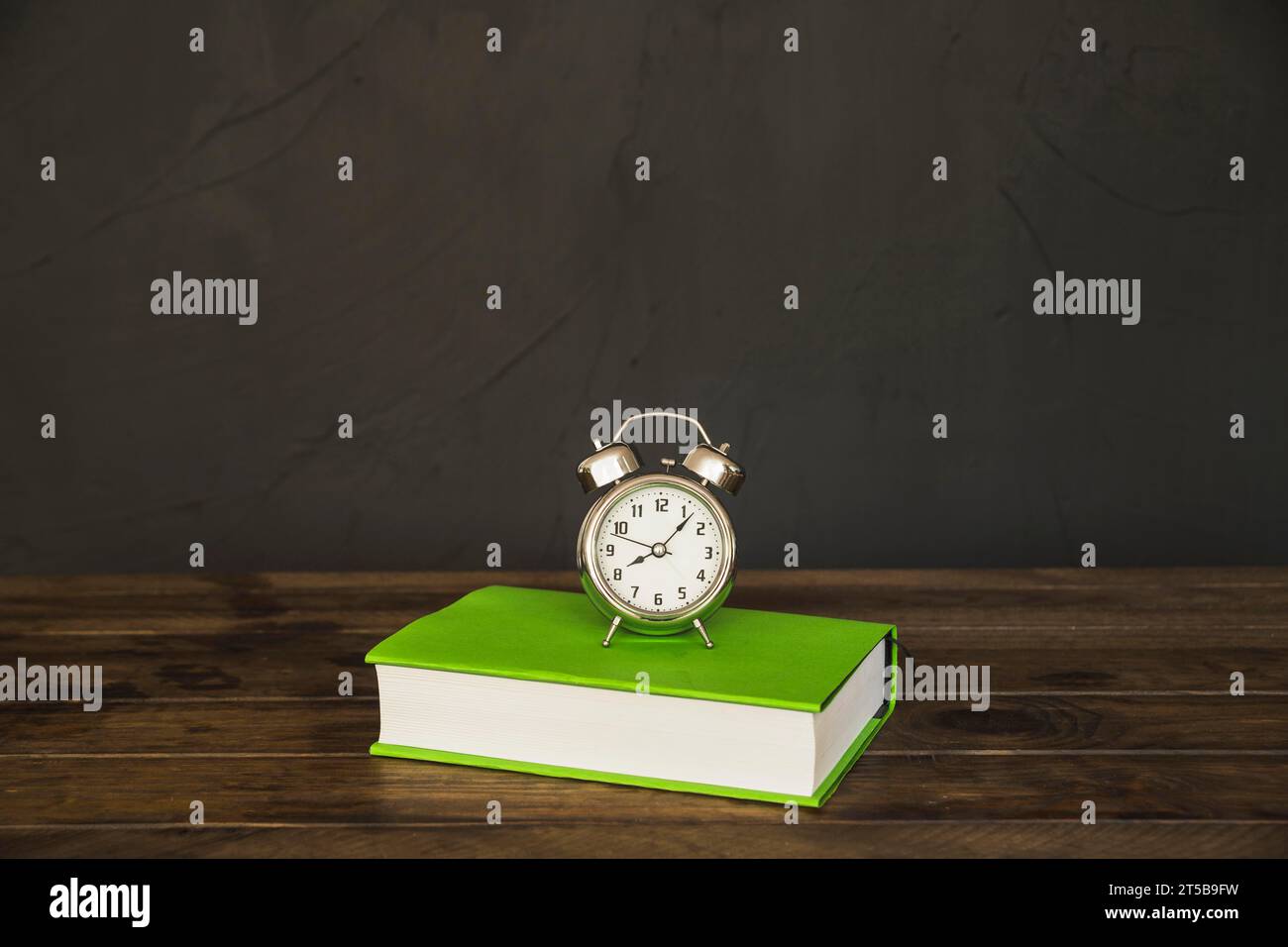 Book table with alarm clocks Stock Photo - Alamy