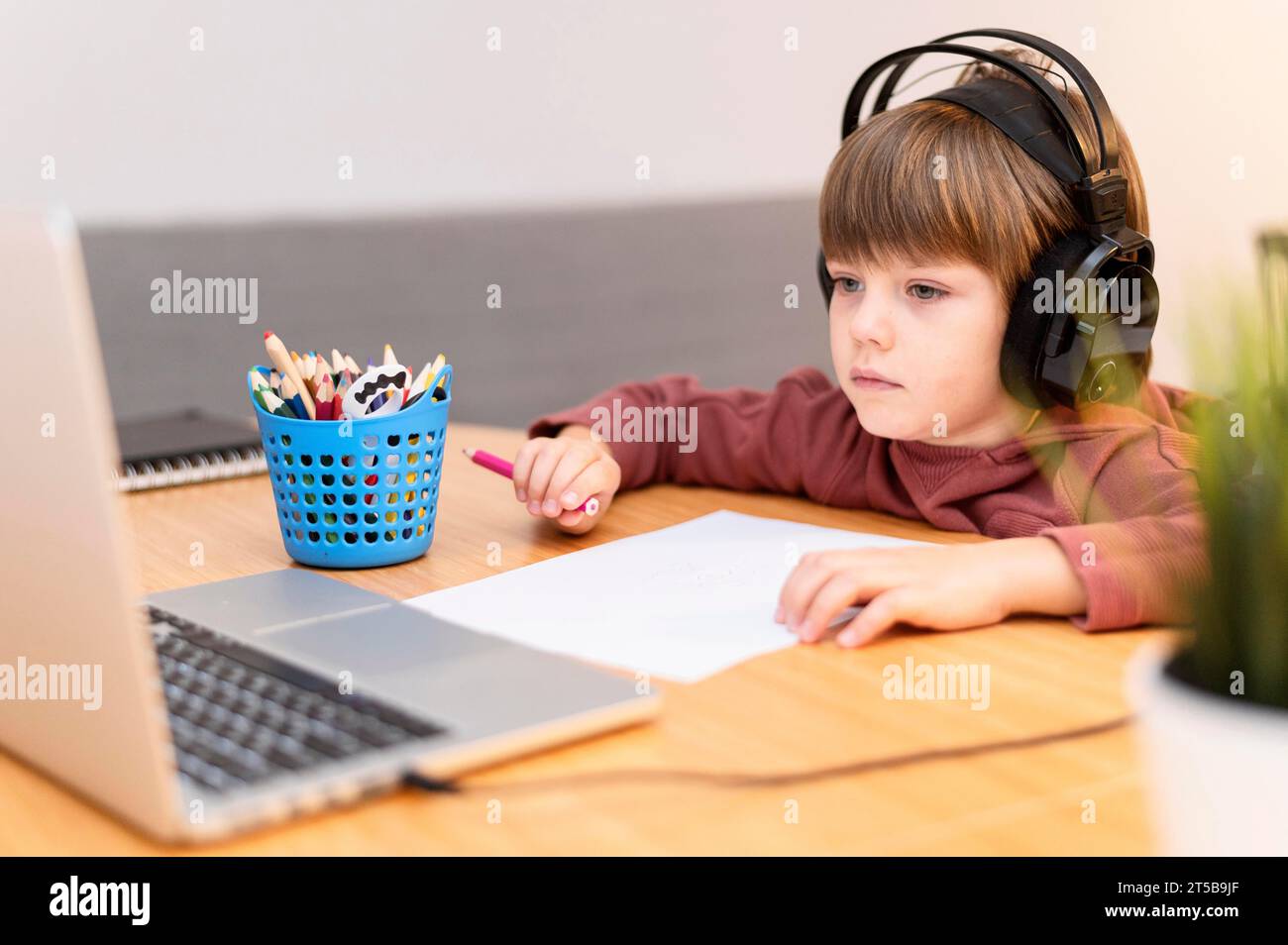 Child wearing headset attending online hi-res stock photography and ...