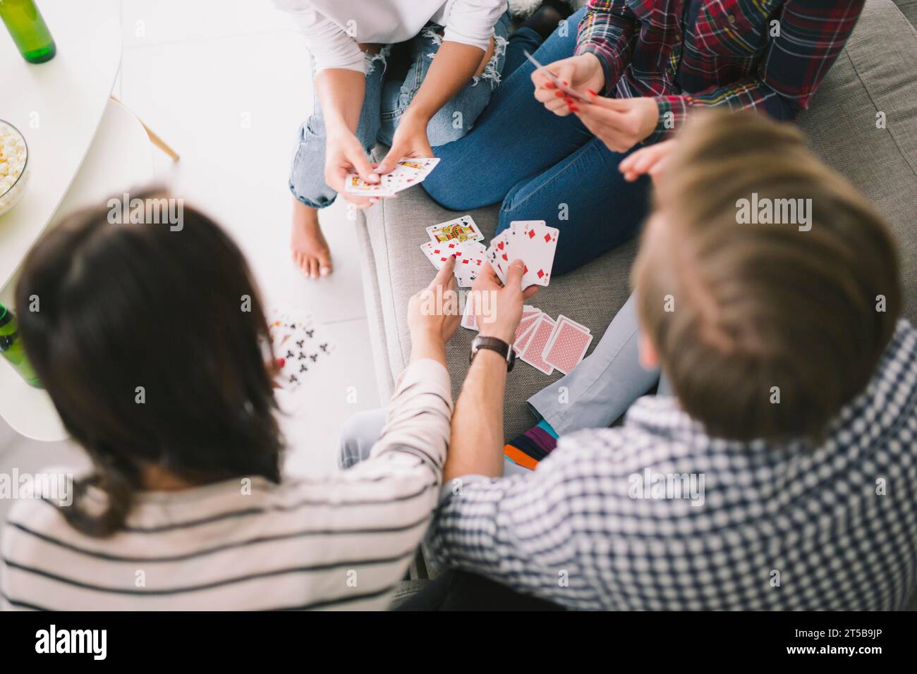 Chilling people playing cards sofa Stock Photo - Alamy