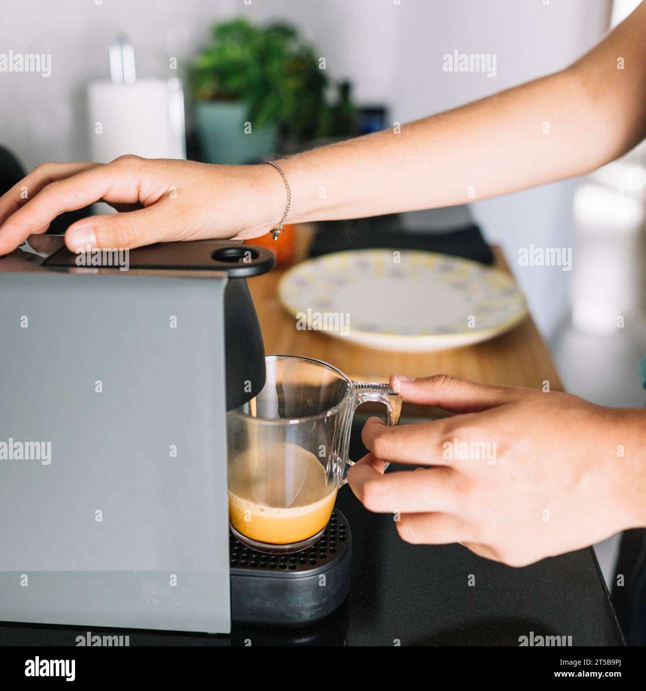 Close up woman taking coffee from coffee machine Stock Photo - Alamy