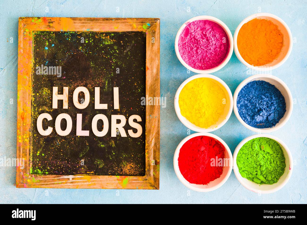Color powder white bowls near wooden slate with holi color text Stock ...