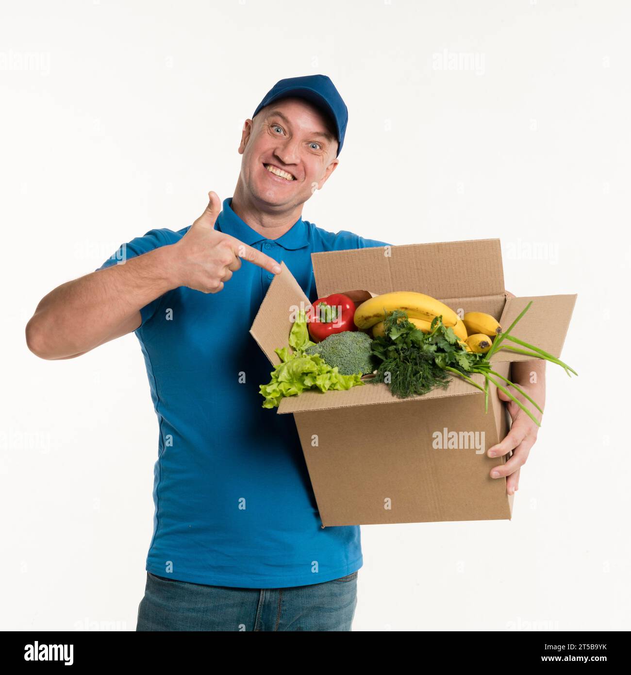 Delivery man pointing grocery box Stock Photo - Alamy