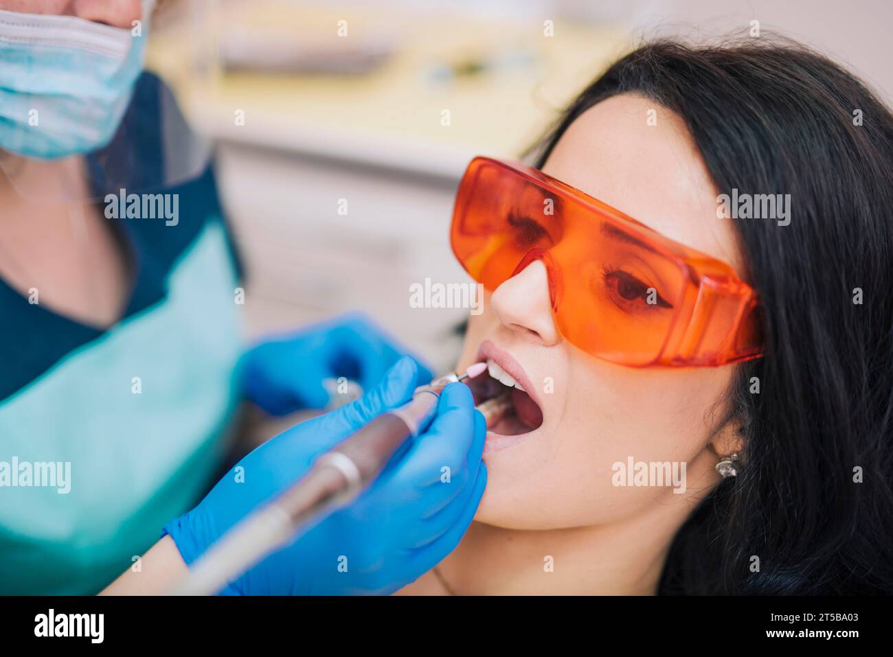 Dentist curing teeth patient glasses Stock Photo - Alamy