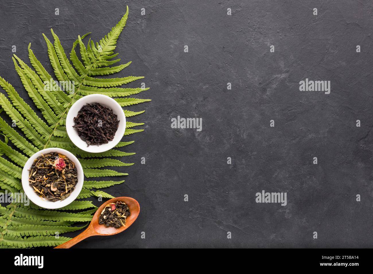 Dried herb tea white ceramic bowl with fern leaves black background ...