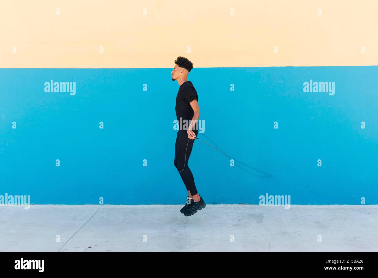 Ethnic man jumping rope street Stock Photo - Alamy