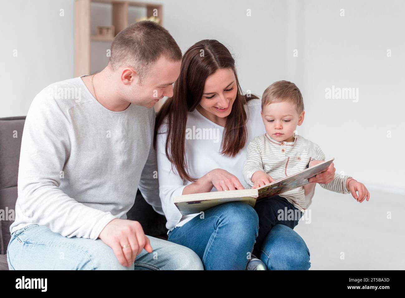 Family with child book home Stock Photo - Alamy