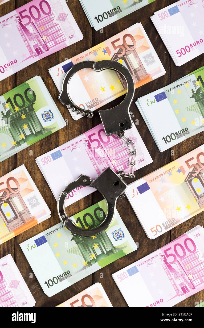 Flat lay banknotes wooden table with handcuffs Stock Photo - Alamy
