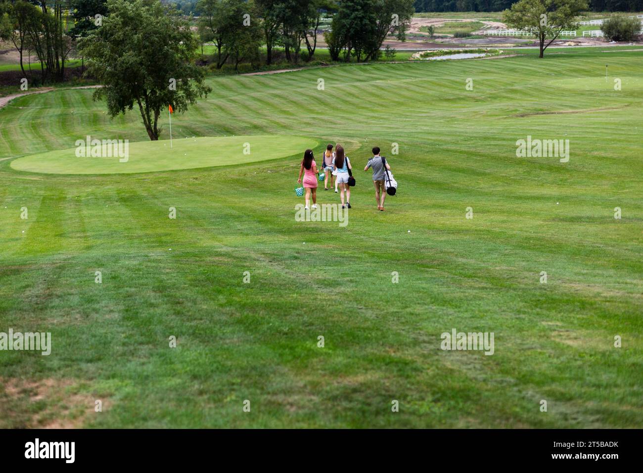 Golf friends leaving golf field Stock Photo - Alamy
