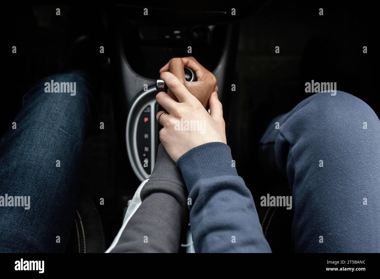 Close up couple holding hands while driving Stock Photo - Alamy
