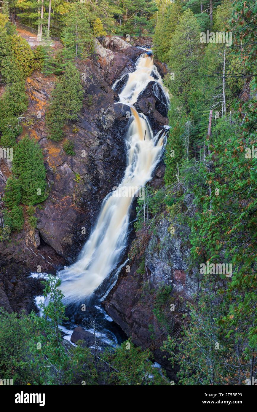 Big Manitou Falls - A tall cascading waterfall in a gorge during autumn ...