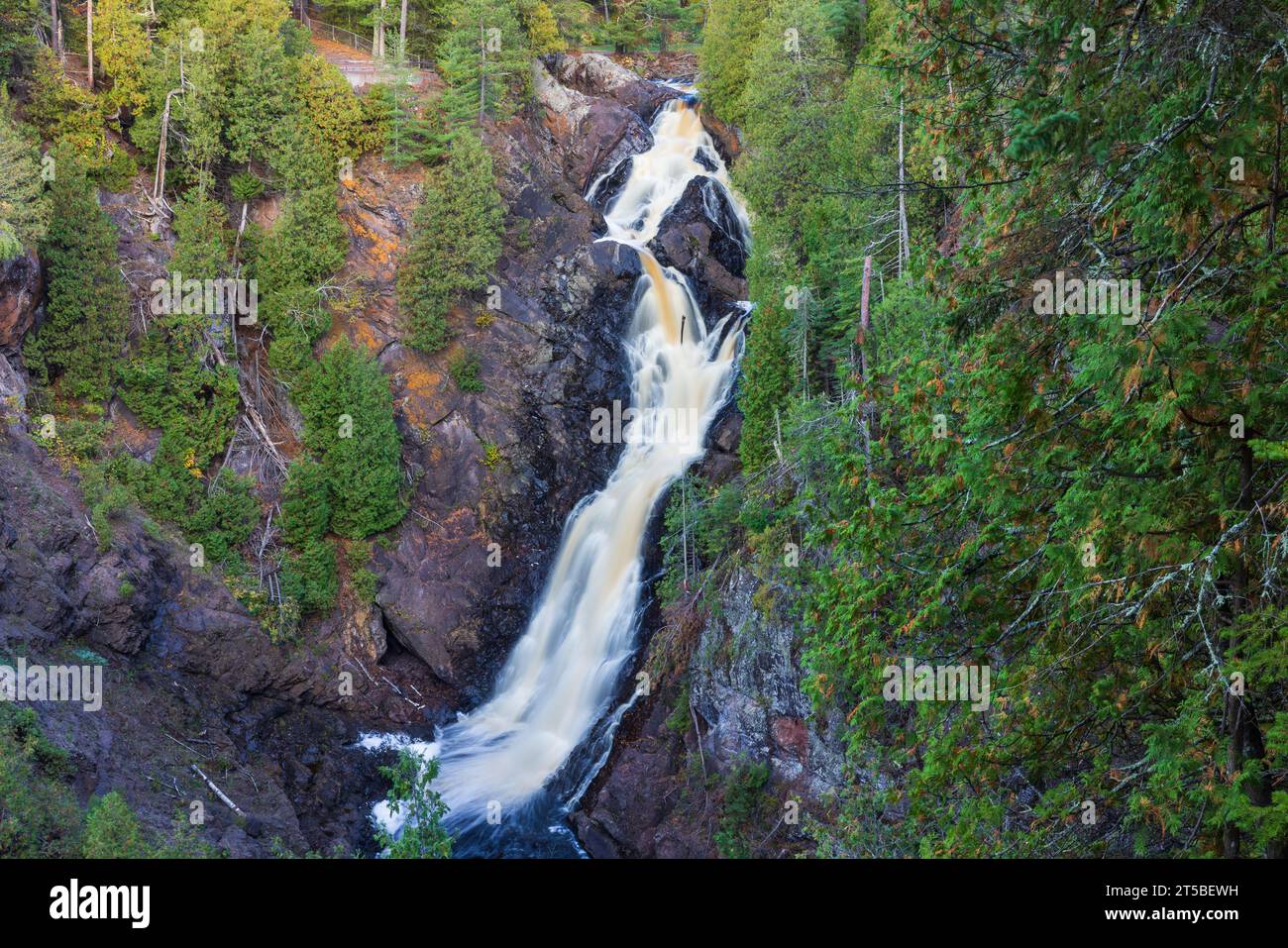 Big Manitou Falls - A tall cascading waterfall in a gorge during autumn ...