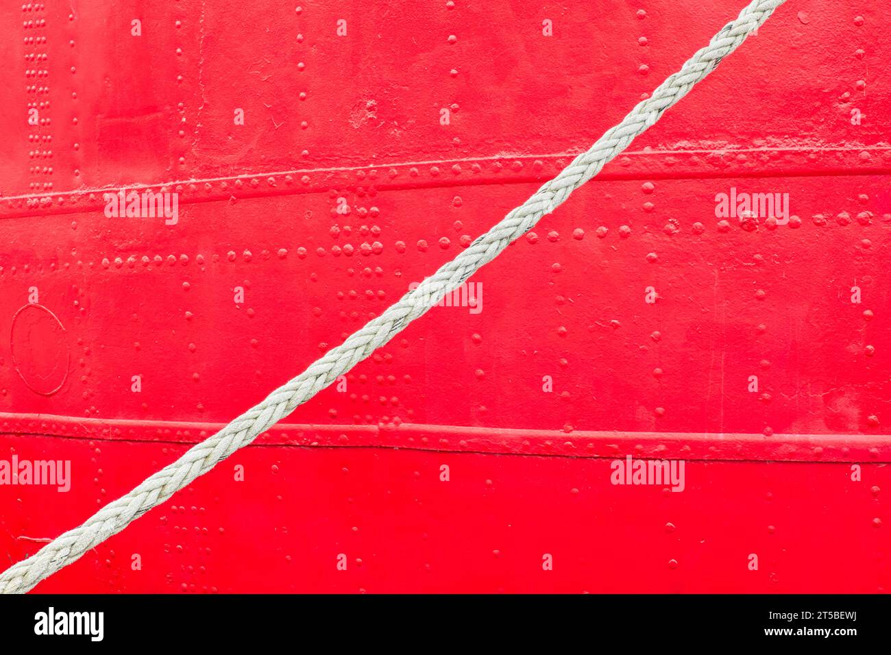 Closeup of mooring rope against red painted ship hull Stock Photo - Alamy