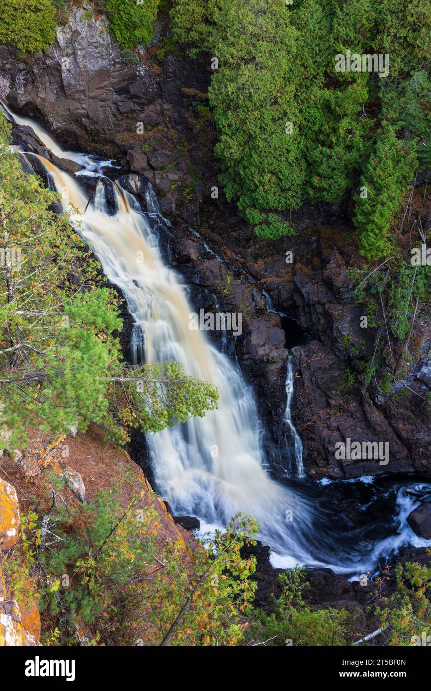 Big Manitou Falls - A tall cascading waterfall in a gorge during autumn ...
