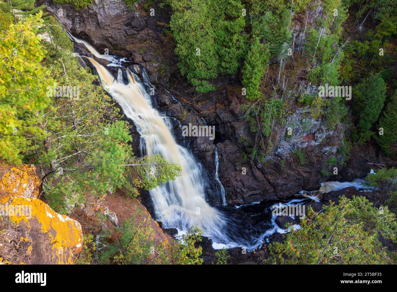 Big Manitou Falls - A tall cascading waterfall in a gorge during autumn ...