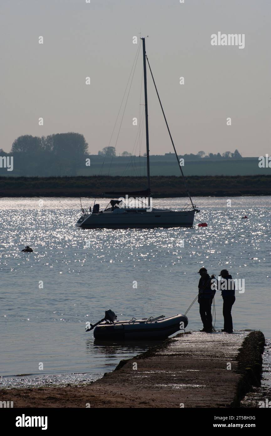 two older men with rubber dinghy and moored sailing boat ramsholt ...