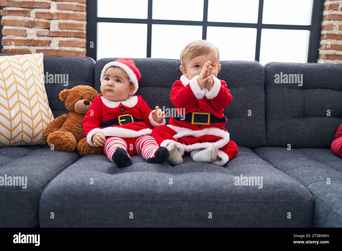 Adorable boy and girl wearing christmas clothes clapping hands at home ...