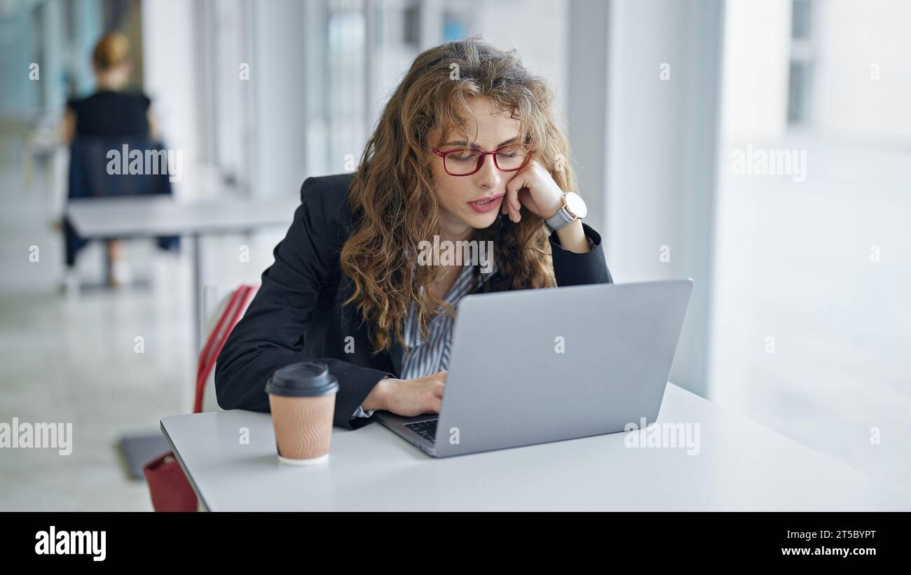Young woman business worker using laptop working tired at the office ...