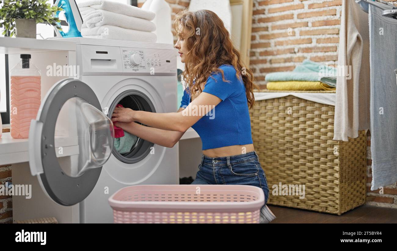 Young woman washing clothes at laundry room Stock Photo - Alamy