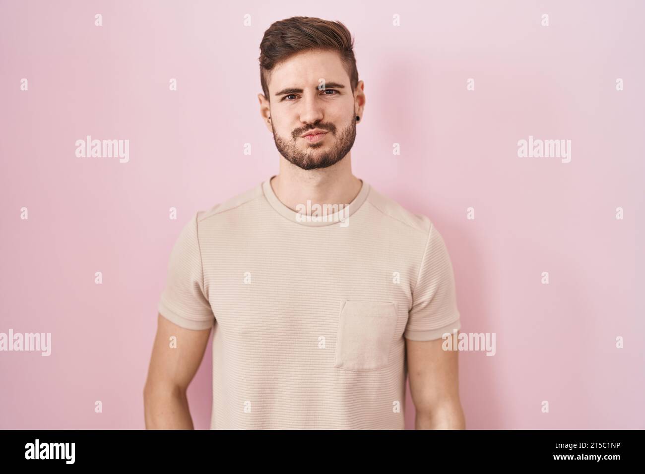 Hispanic man with beard standing over pink background puffing cheeks ...