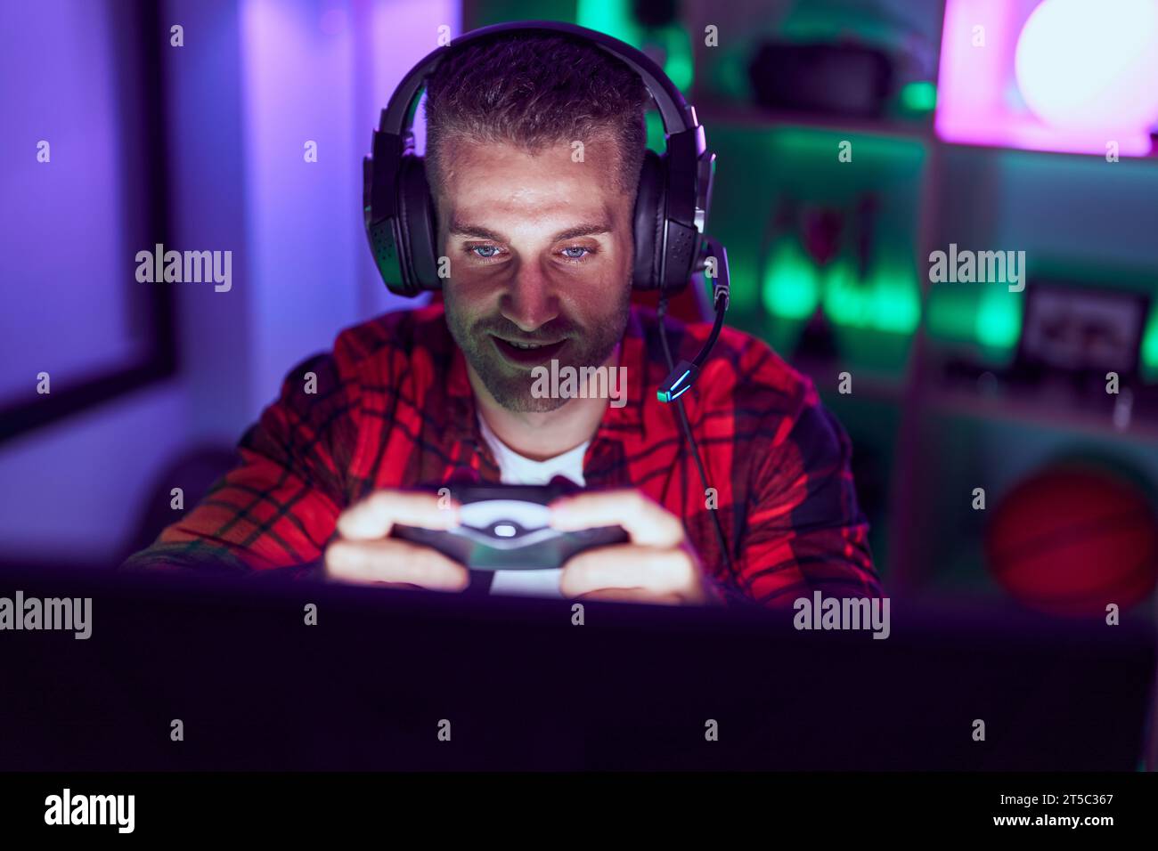 Young caucasian man streamer playing video game using joystick at ...