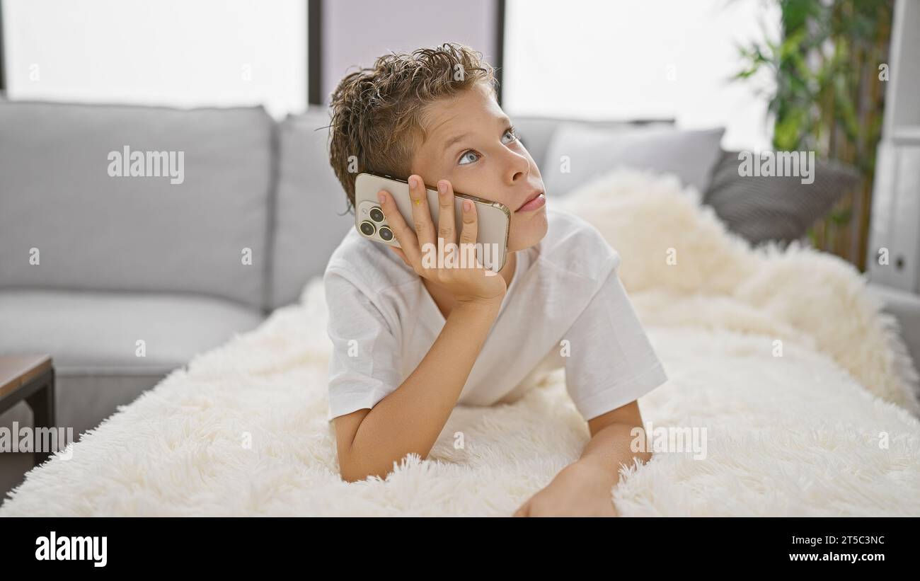 Adorable blond boy, deeply engrossed in a serious phone conversation ...