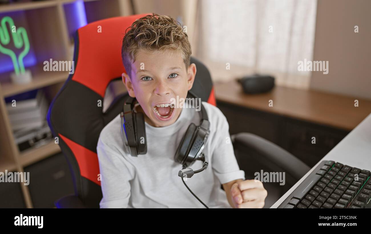 Adorable blond boy streaming victorious celebration, gaming enthusiast ...