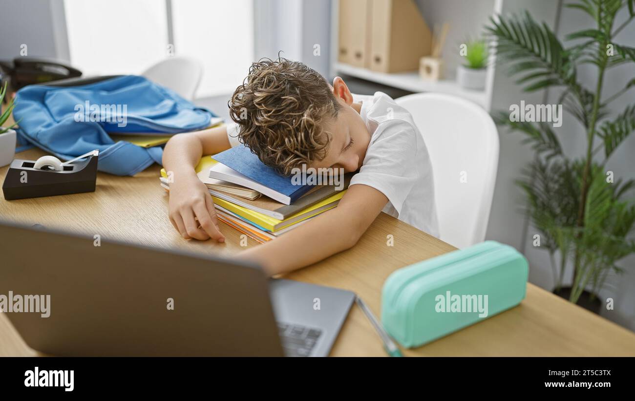 Adorable blond boy student, tired yet diligent, caught sleeping on his ...