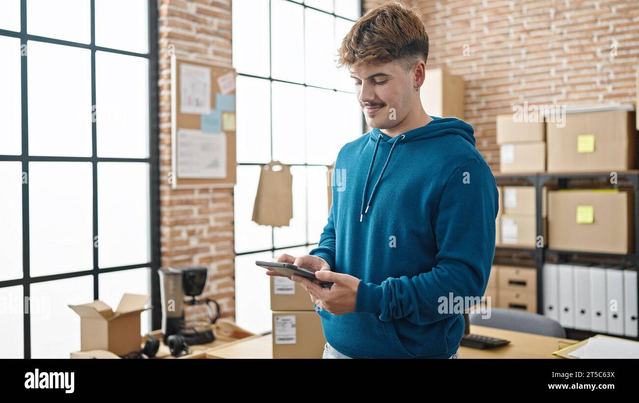 Young hispanic man ecommerce business worker using touchpad smiling at ...