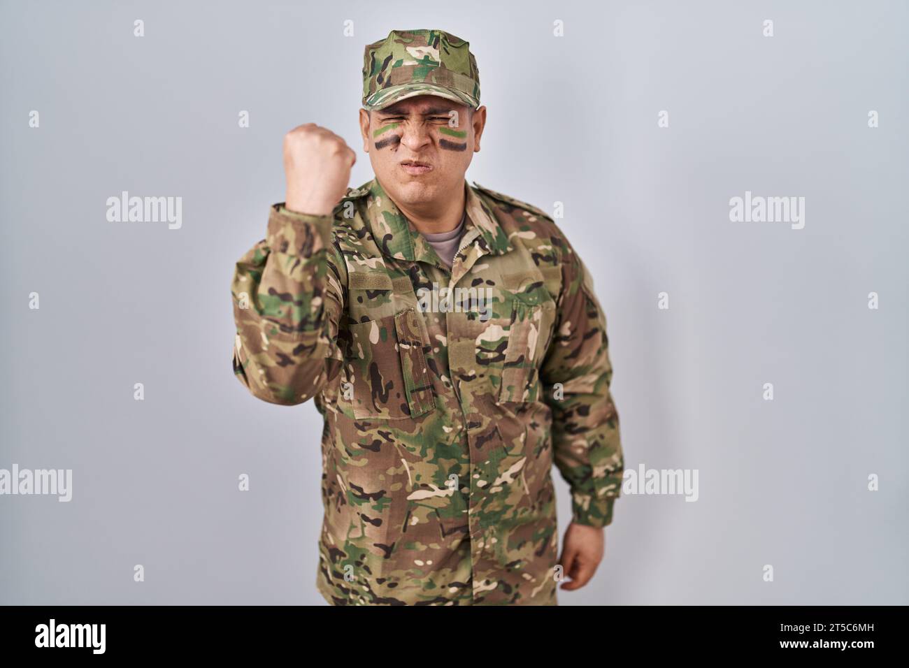 Hispanic young man wearing camouflage army uniform angry and mad ...