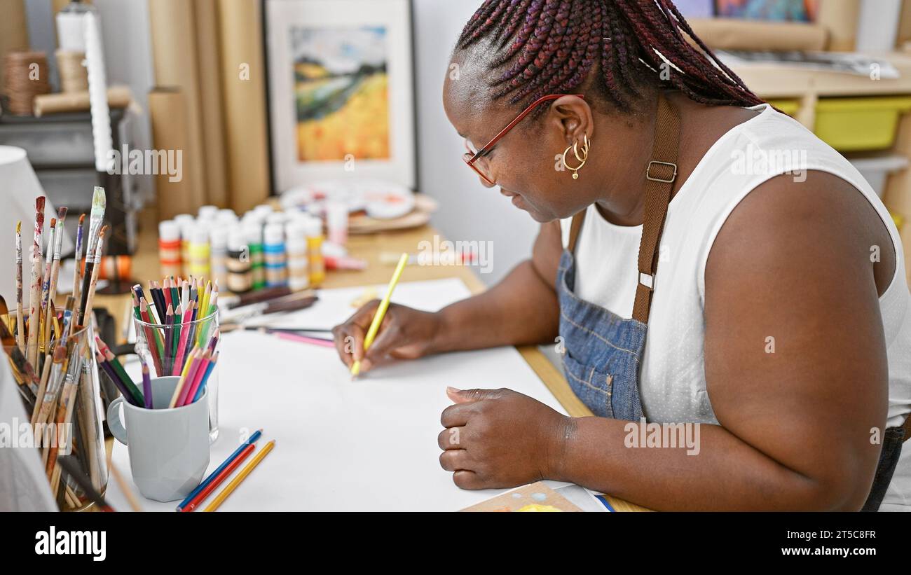Focused african american woman, captivating artist, drawing with ...
