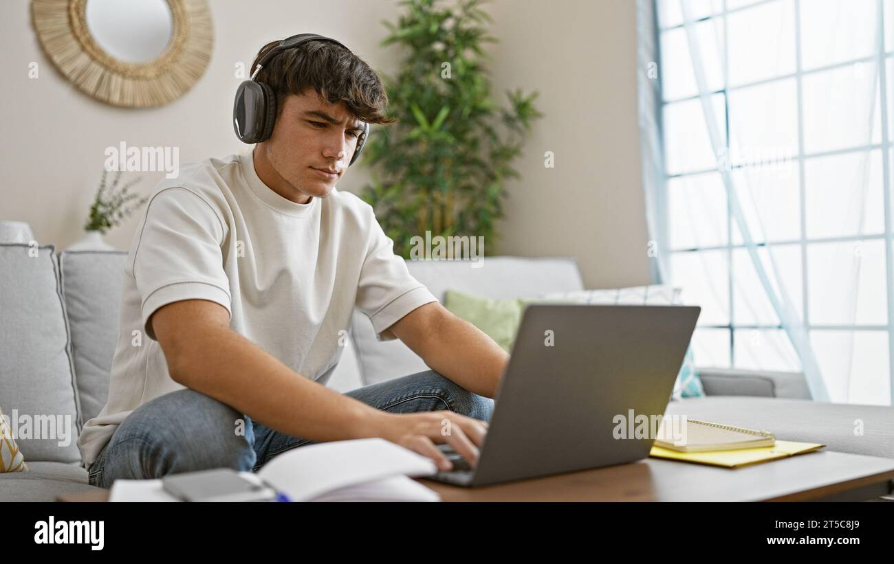 Engrossed young hispanic male student chilling at home, sitting on ...
