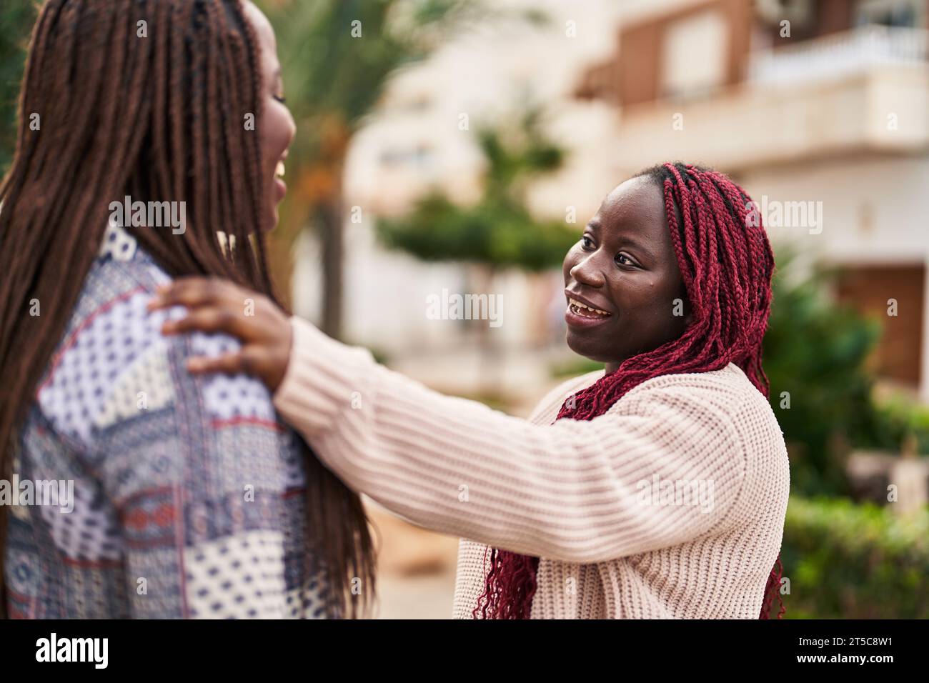 African american women friends standing together speaking at park Stock ...