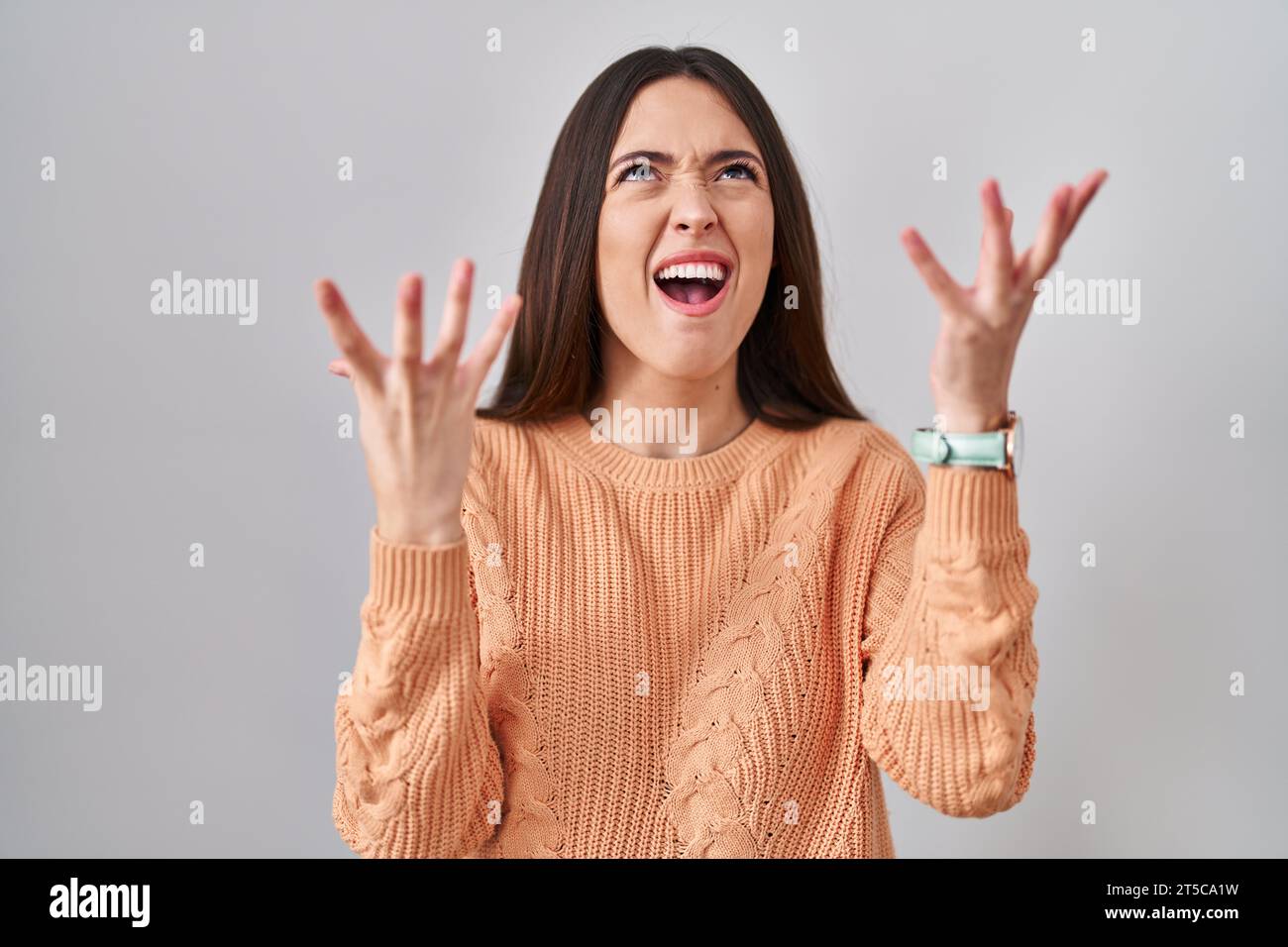 Young brunette woman standing over white background crazy and mad ...
