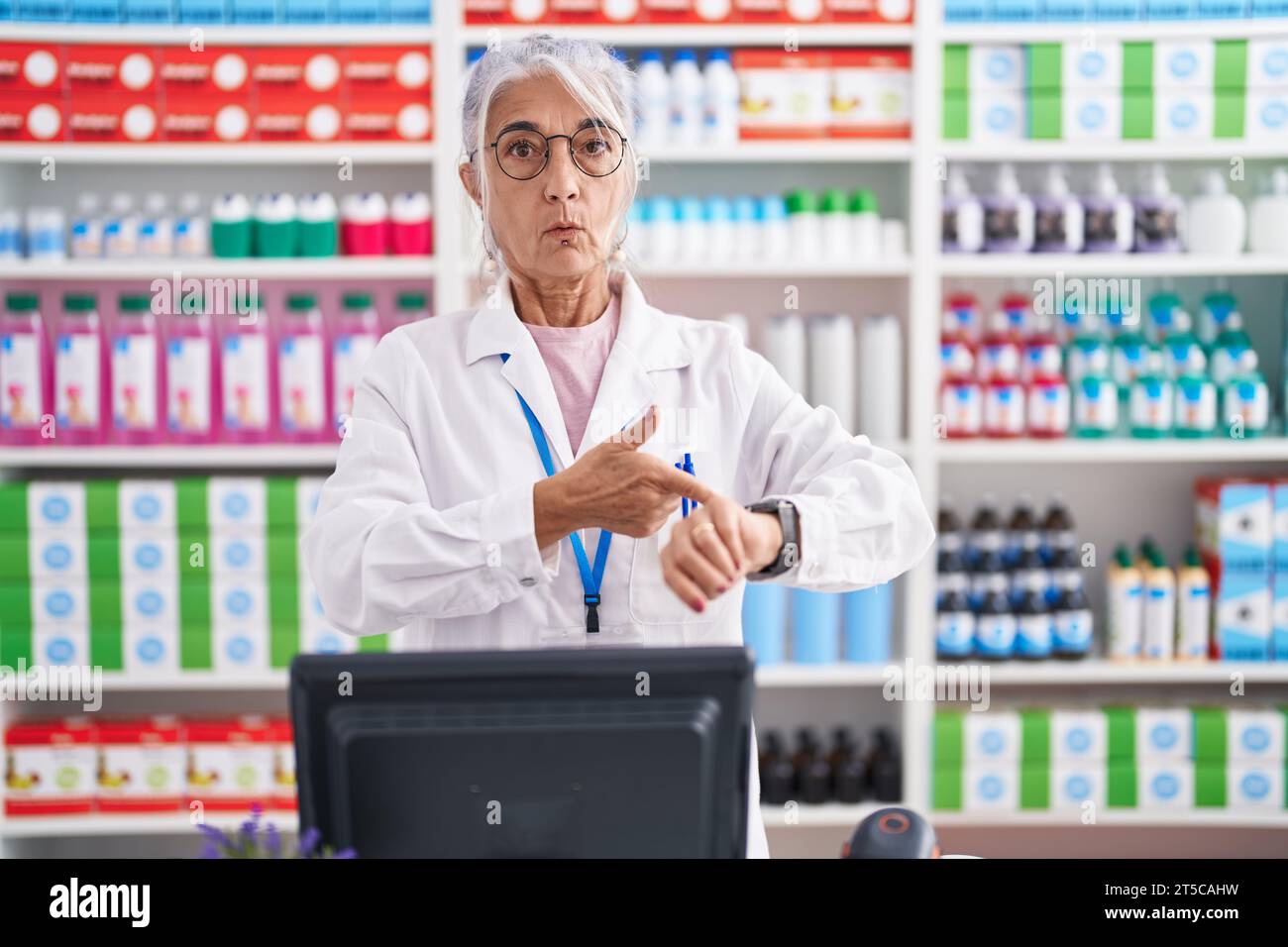Middle age woman with tattoos working at pharmacy drugstore in hurry ...