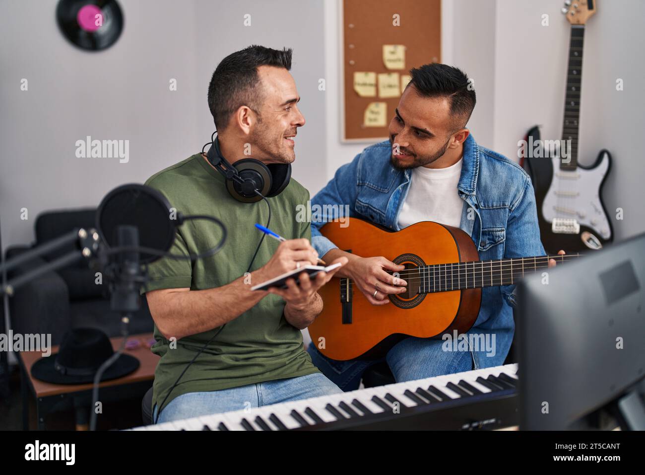 Two men musicians composing song playing classical guitar at music ...