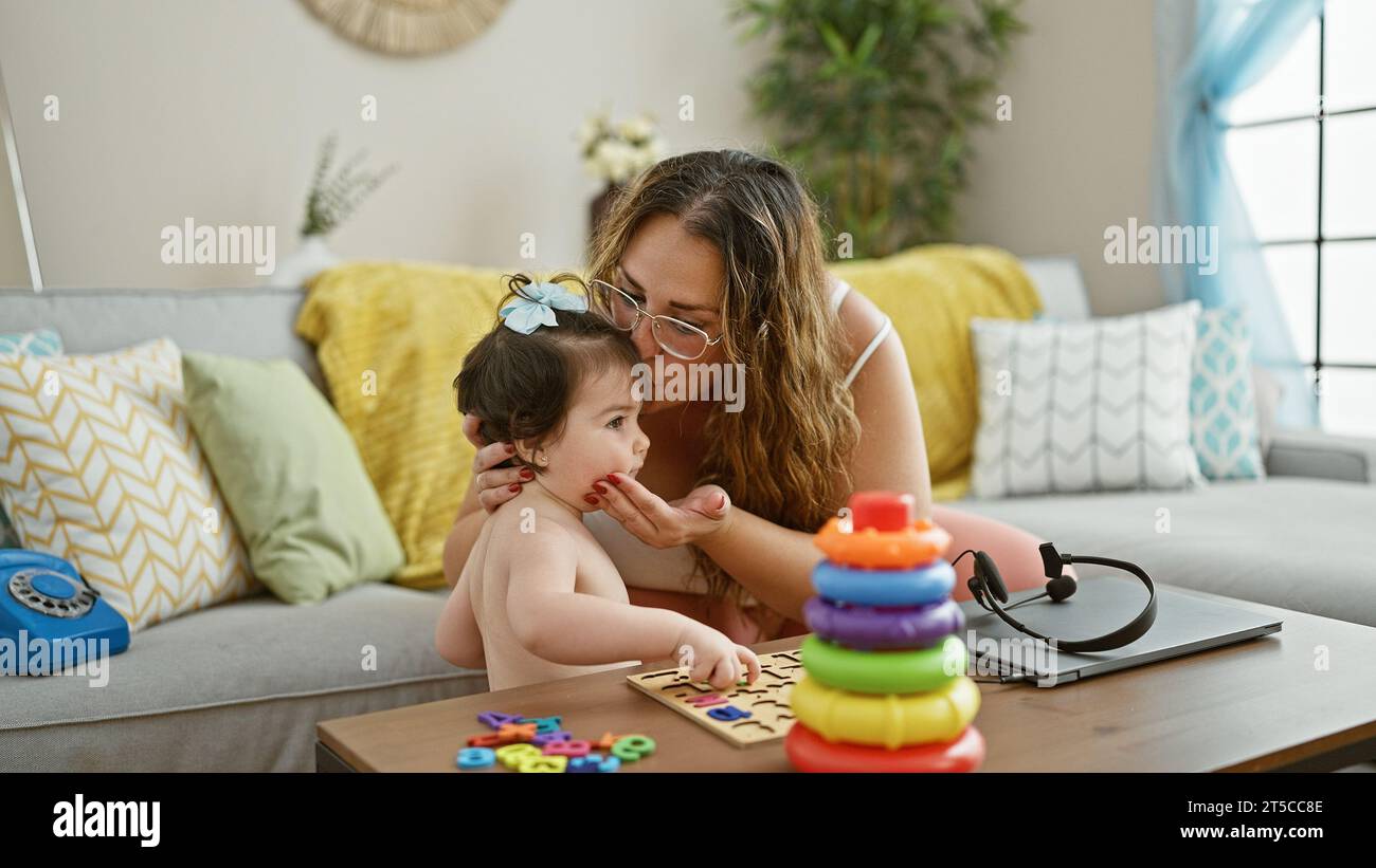 Mother and daughter bonding, engaged in a fun maths game on the sofa at home, mum lovingly ...