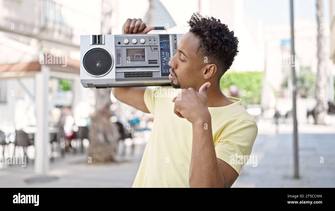 African american man holding boombox doing thumb up gesture at street ...