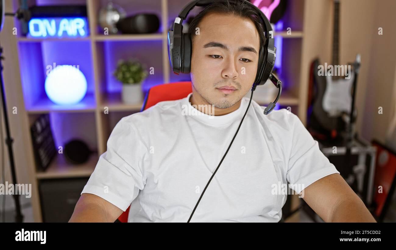 Concentrated young chinese man, a tech-enthusiast streamer, seriously ...