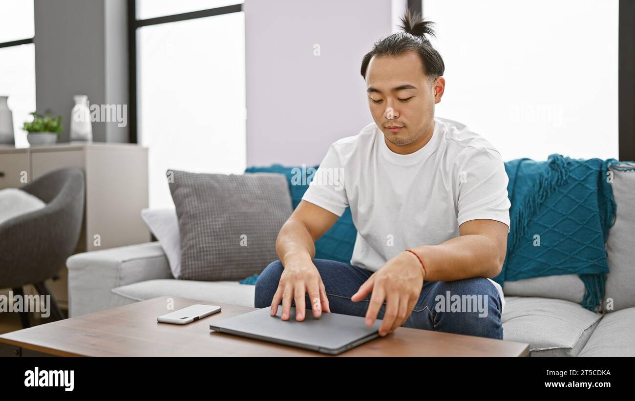 Handsome young chinese man, relaxed yet concentrated, opening his ...