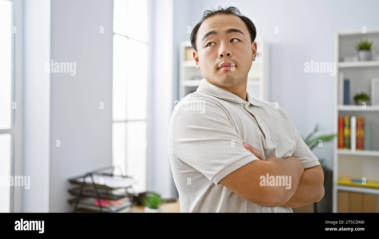 Serious young chinese business worker, a successful man standing ...