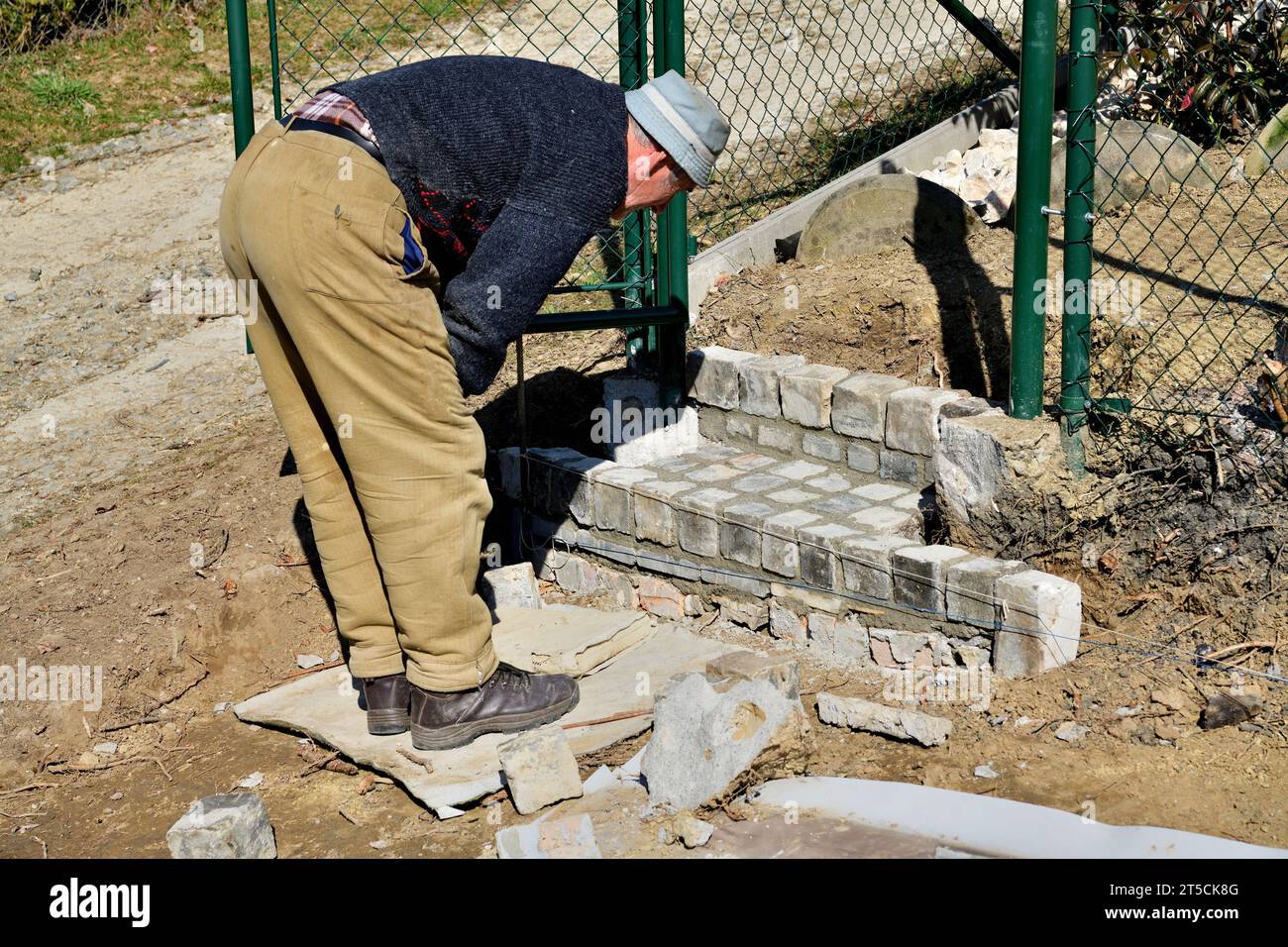 Bricklayer assembles and bricks the stairway around the house from ...