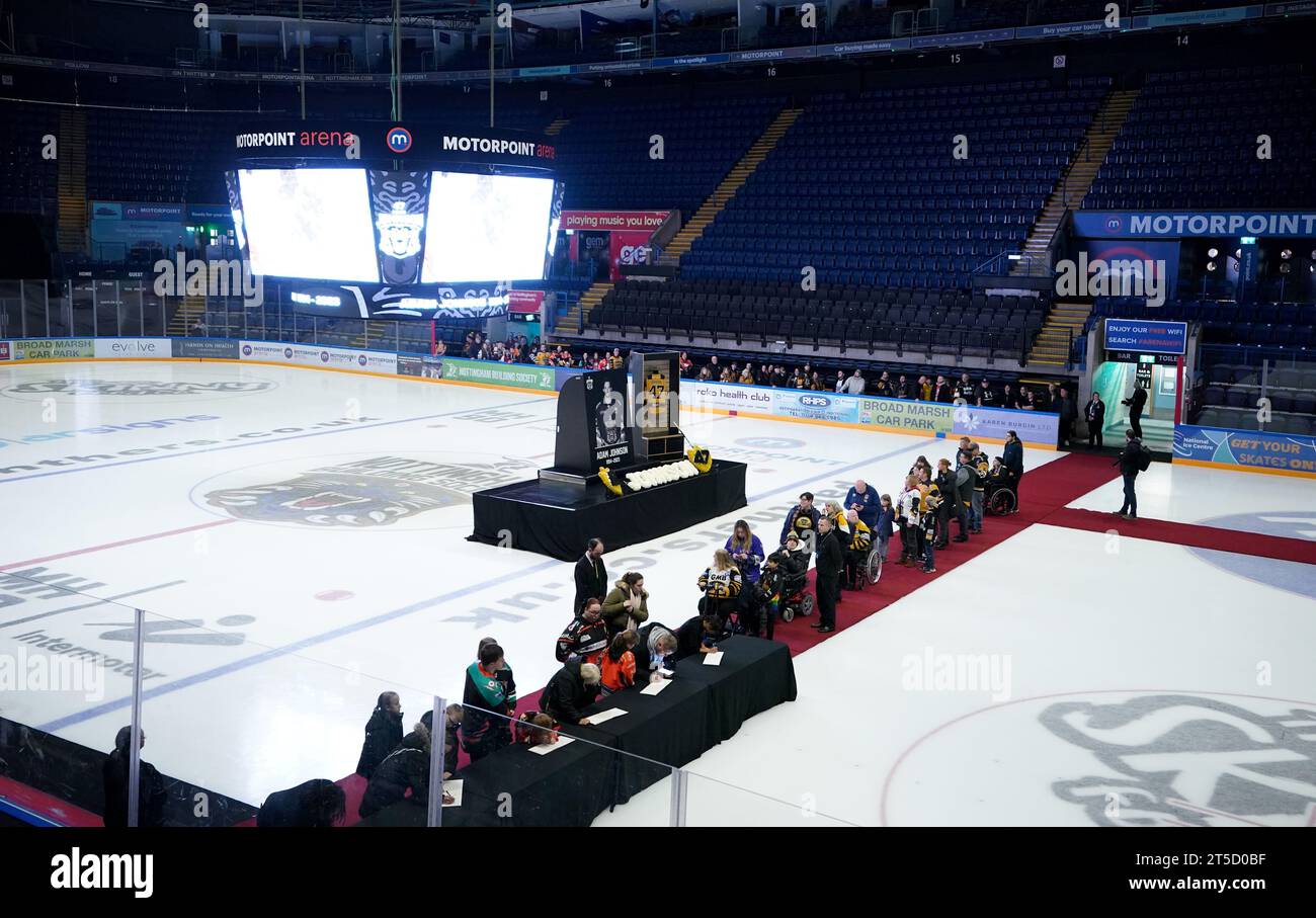 People queue to sign a book of condolence as they attend a memorial for ...