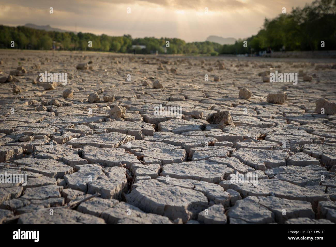 dry cracked earth, or parched river, with dramatic sky and lighting ...