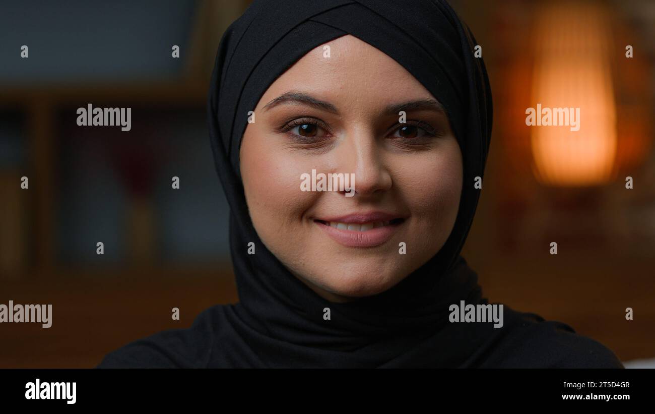 Portrait of Arabian muslim woman in black traditional hijab looking at ...