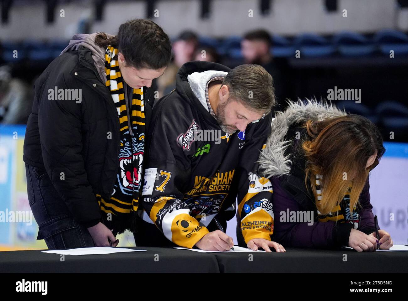 People sign a book of condolence as they attend a memorial for ...