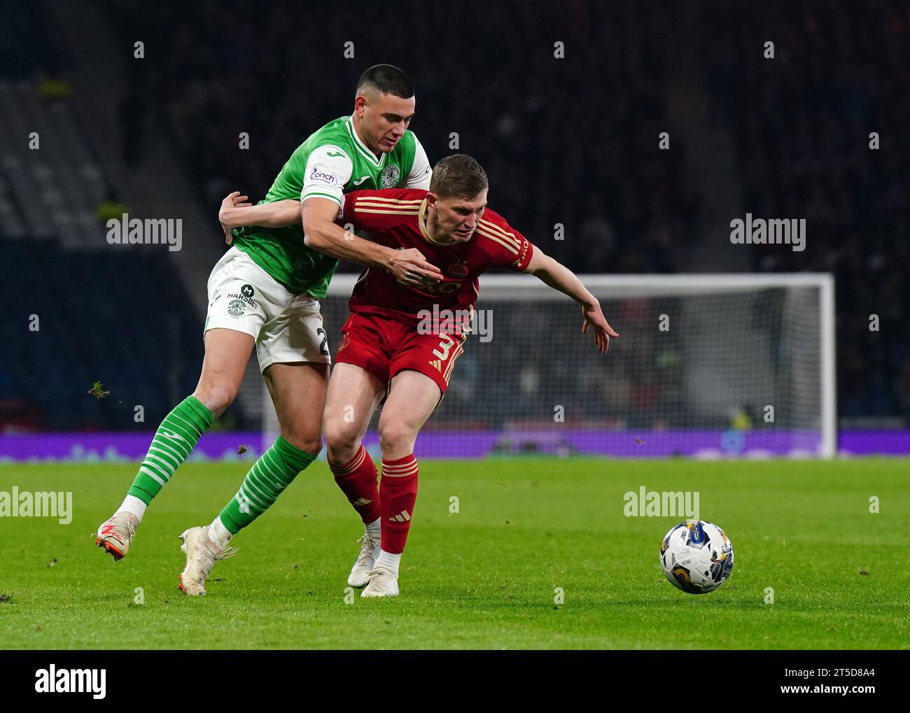 Aberdeen's Jack Mackenzie (right) holds off Hibernian's Lewis Miller during the Viaplay Cup semi ...