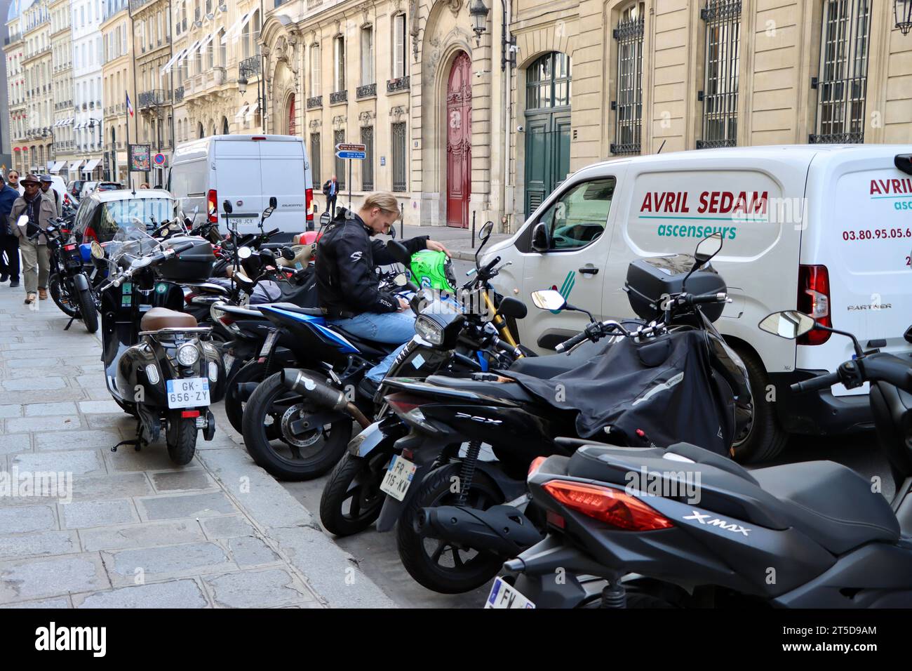 Blond man texting on parked motorcycle on Faubourg Saint-Honore in ...